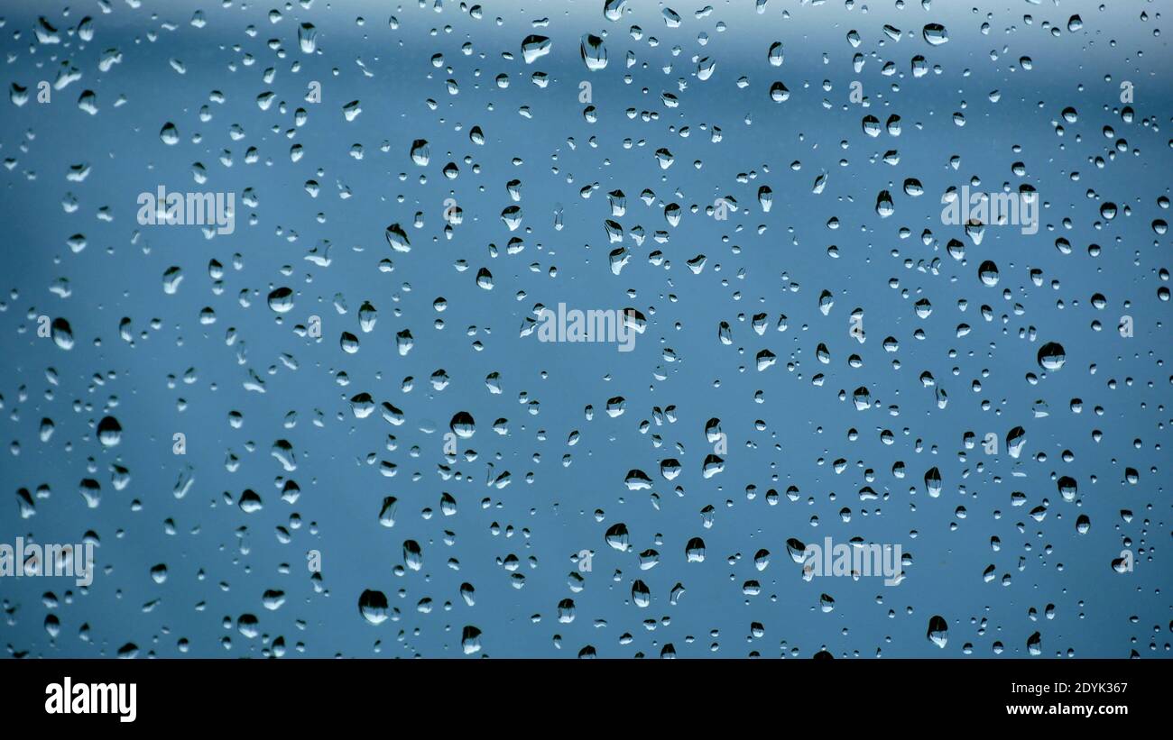 Crystal clear water drops on the window with blue background; raindrops ...