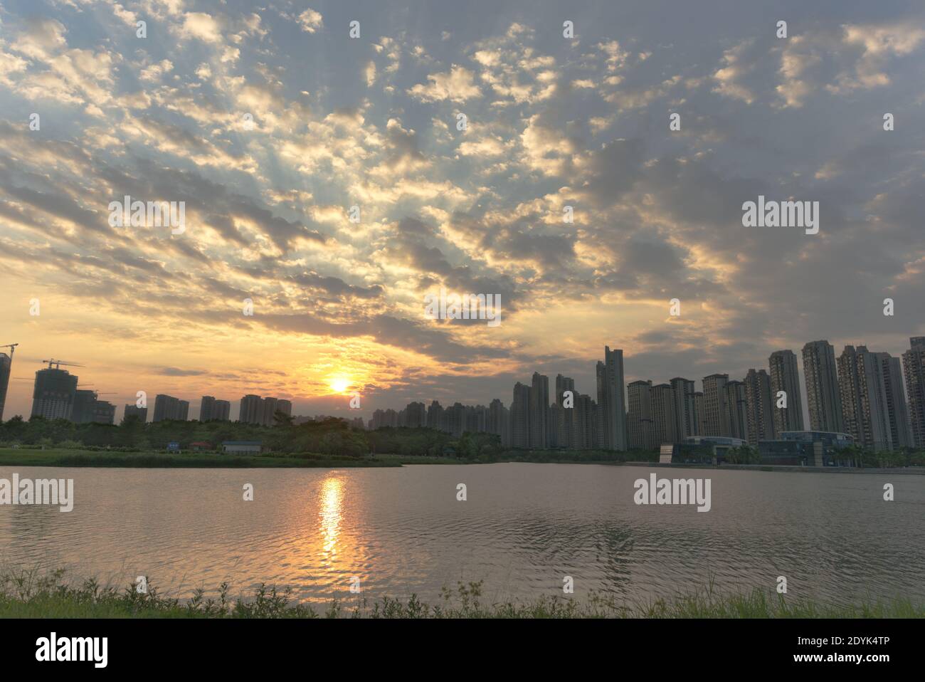 Sunset scenery of a city park; sunset reflects on a lake surface in ...