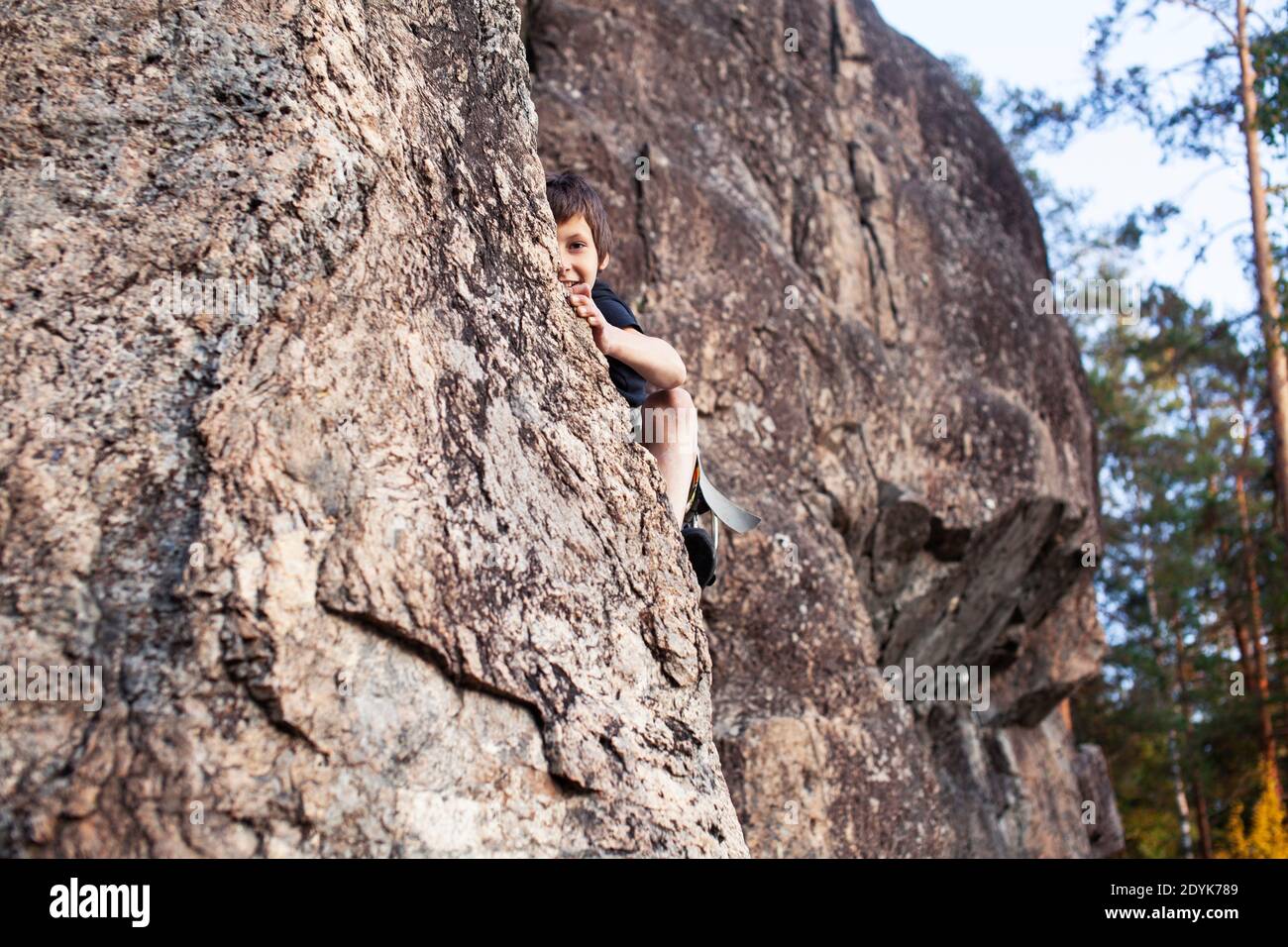 cute teen kid climbing on rock with insurance, lifestyle sport people ...
