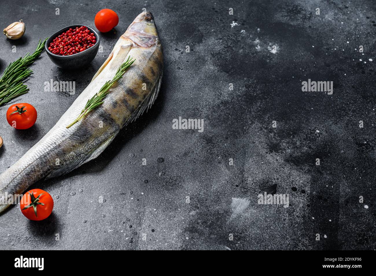 Raw zander, walleye fish with herbs. Black background. Top view. Copy ...