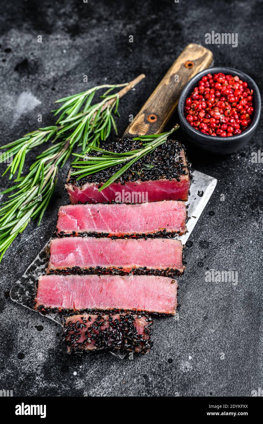 Fried fish tuna steak slices on a meat cleaver. Black background. Top ...