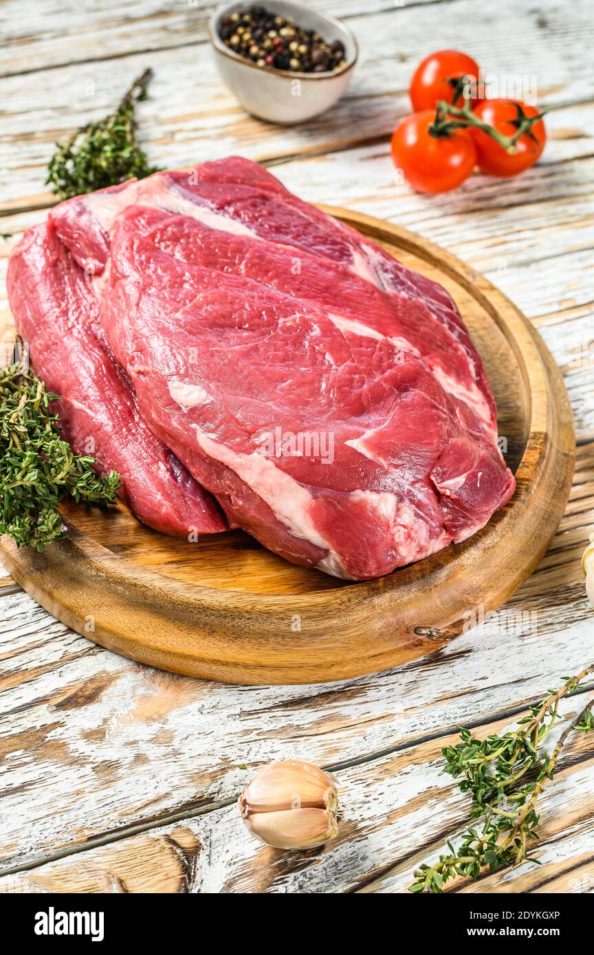 Raw Round beef cut on a wooden board. White background. Top view Stock ...