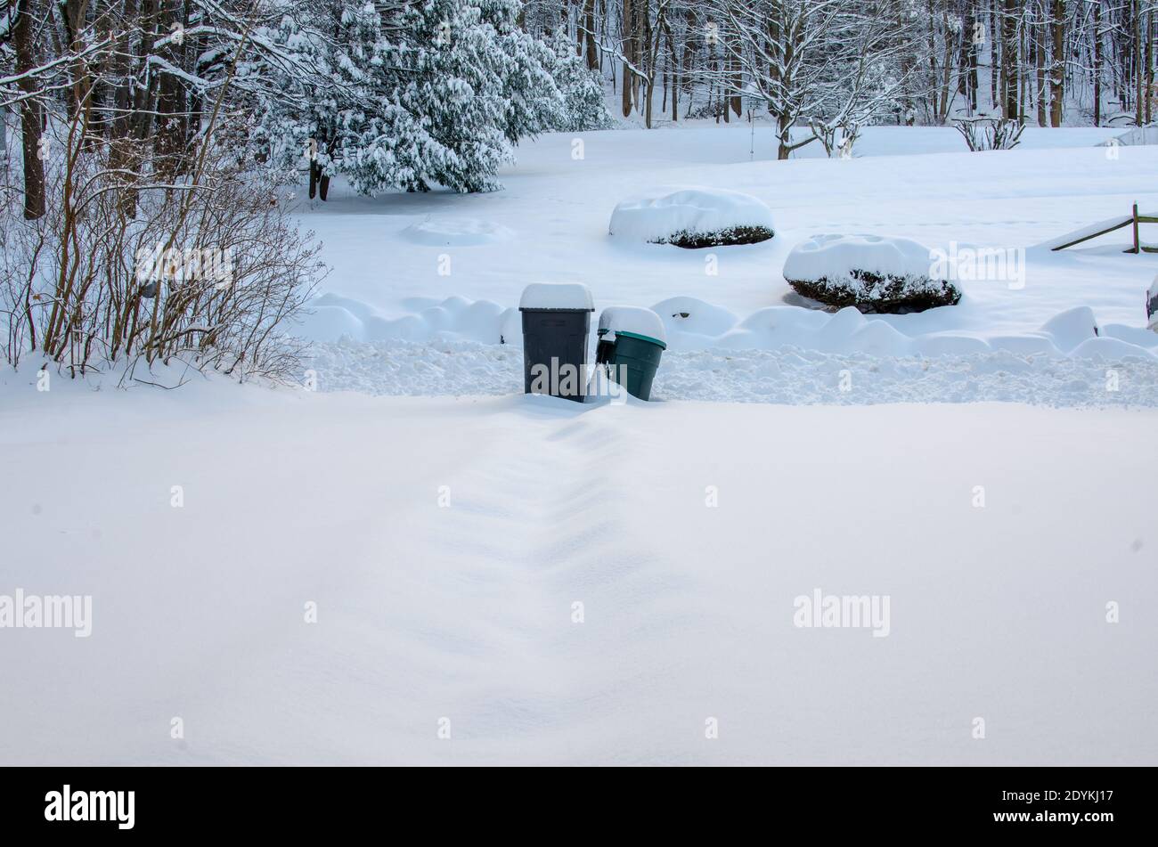 Two trash cans at the end of a snowed in driveway Stock Photo - Alamy