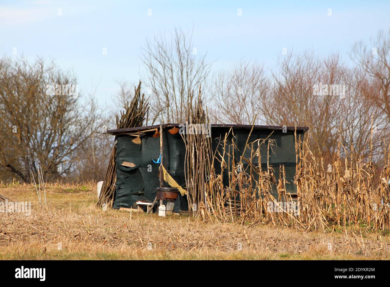 Makeshift homemade small wooden shed covered with protective nylon ...