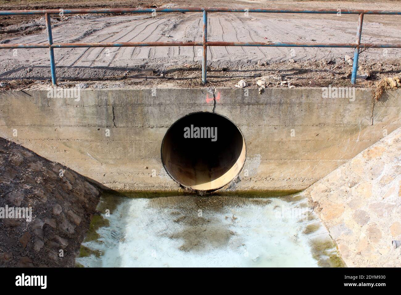 Small bridge with partially rusted metal railing over large diameter ...