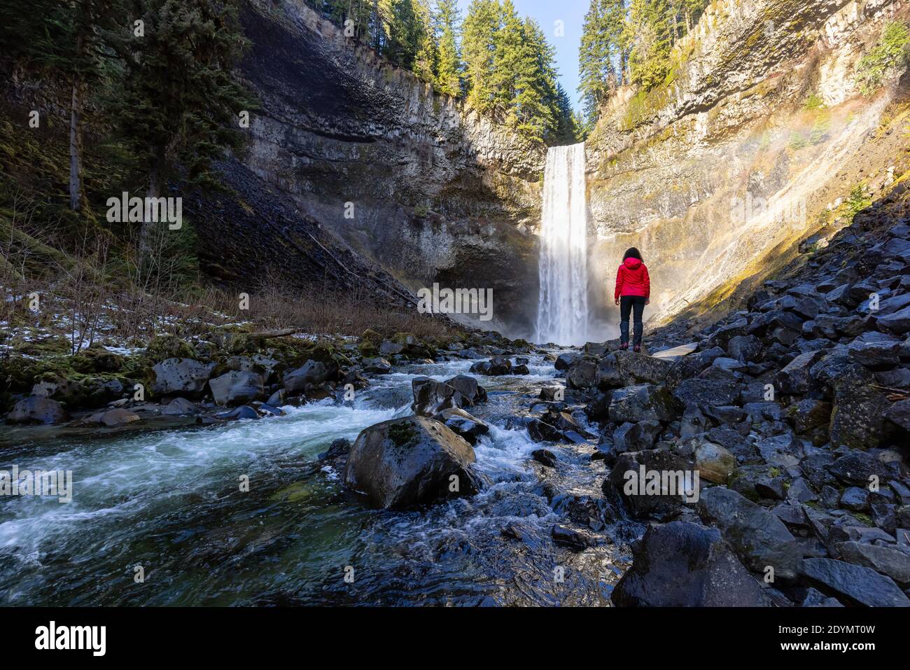 Girl watching a beautiful waterfall in Canadian Nature Stock Photo - Alamy