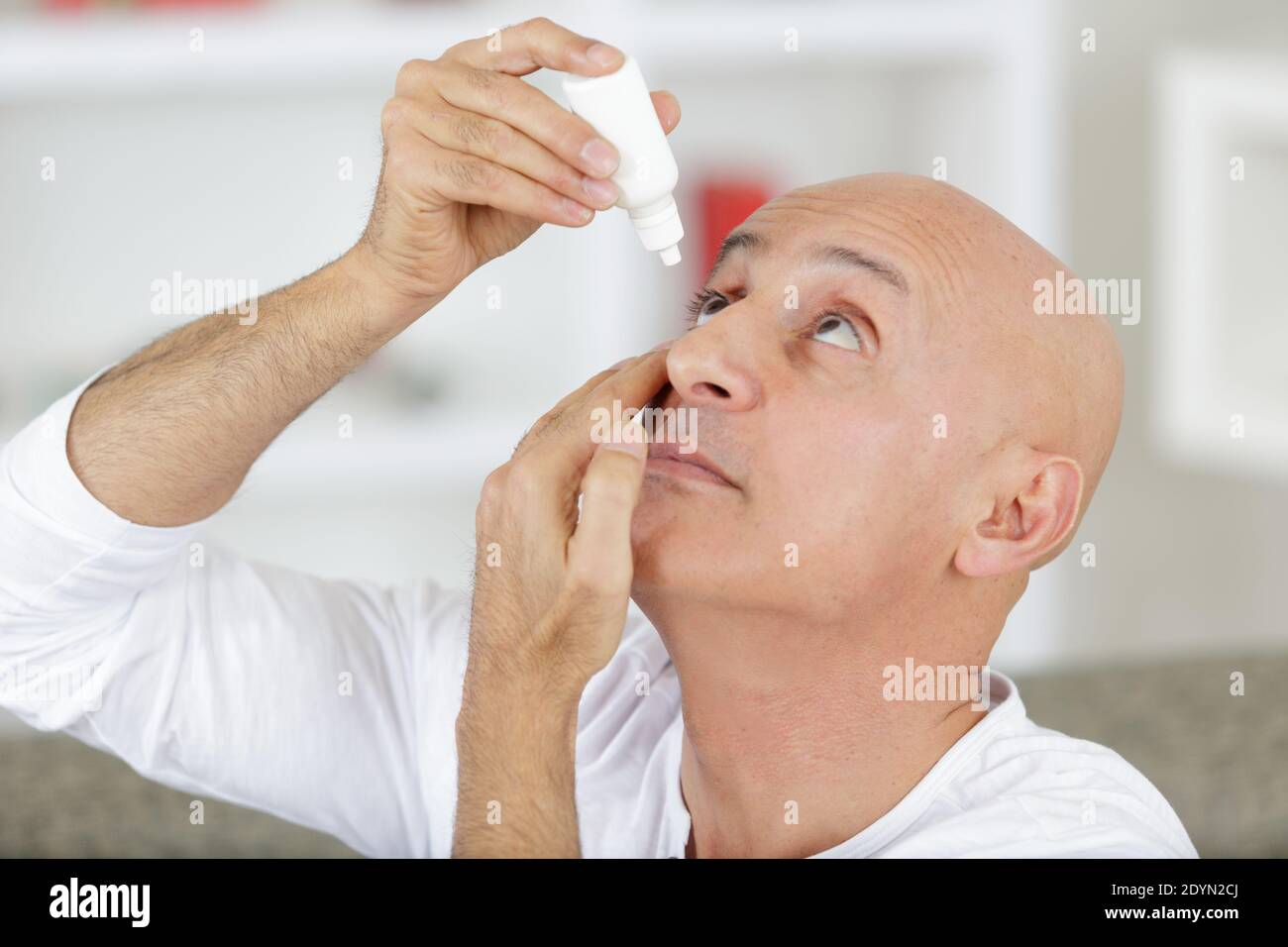 Man using eye drops hi-res stock photography and images - Alamy