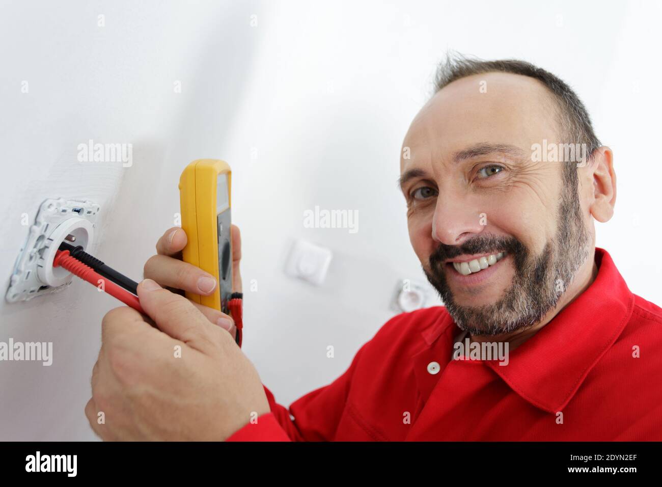 electrician testing socket in new house Stock Photo - Alamy