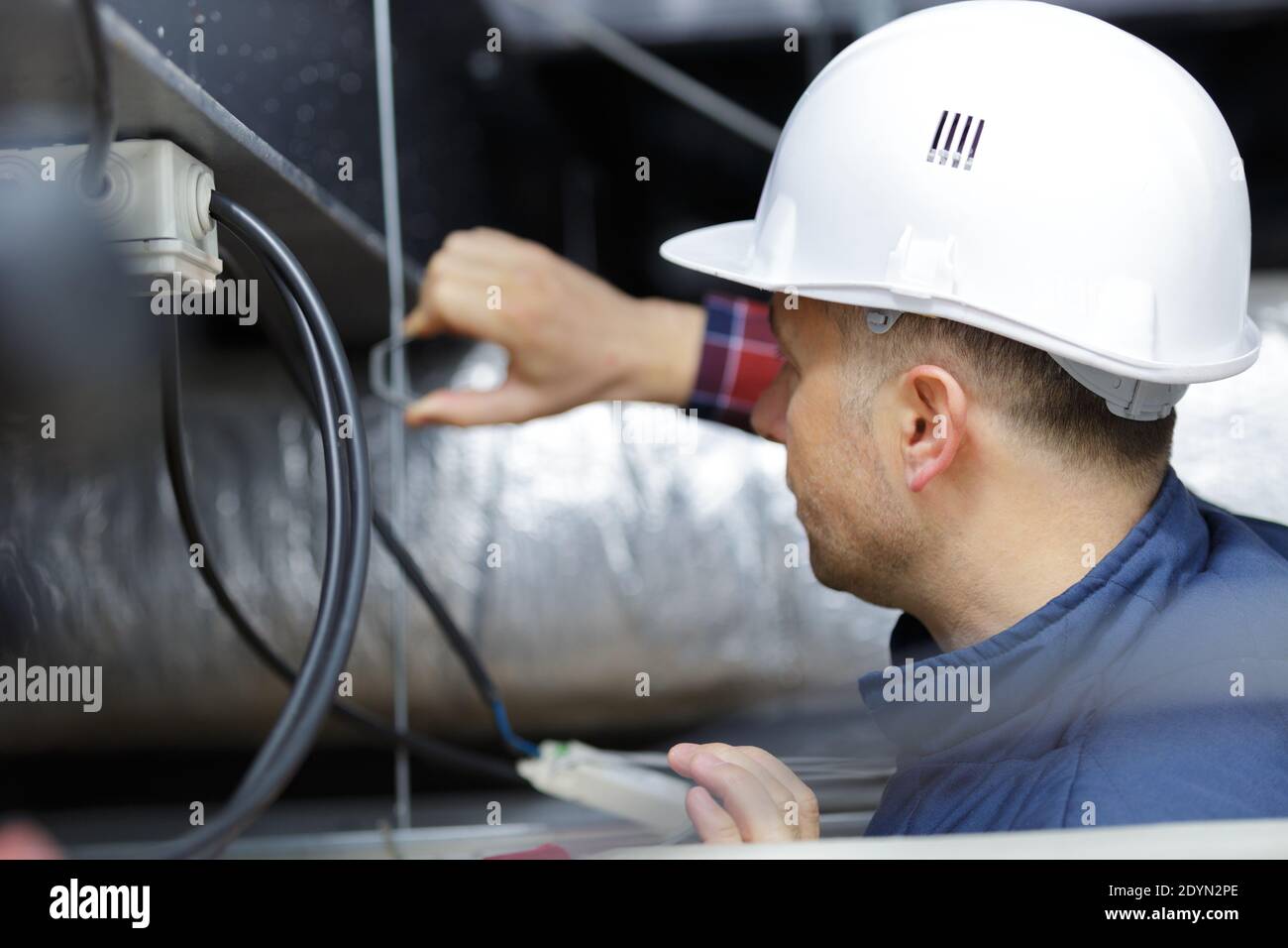 electrician installing cables in roof Stock Photo - Alamy