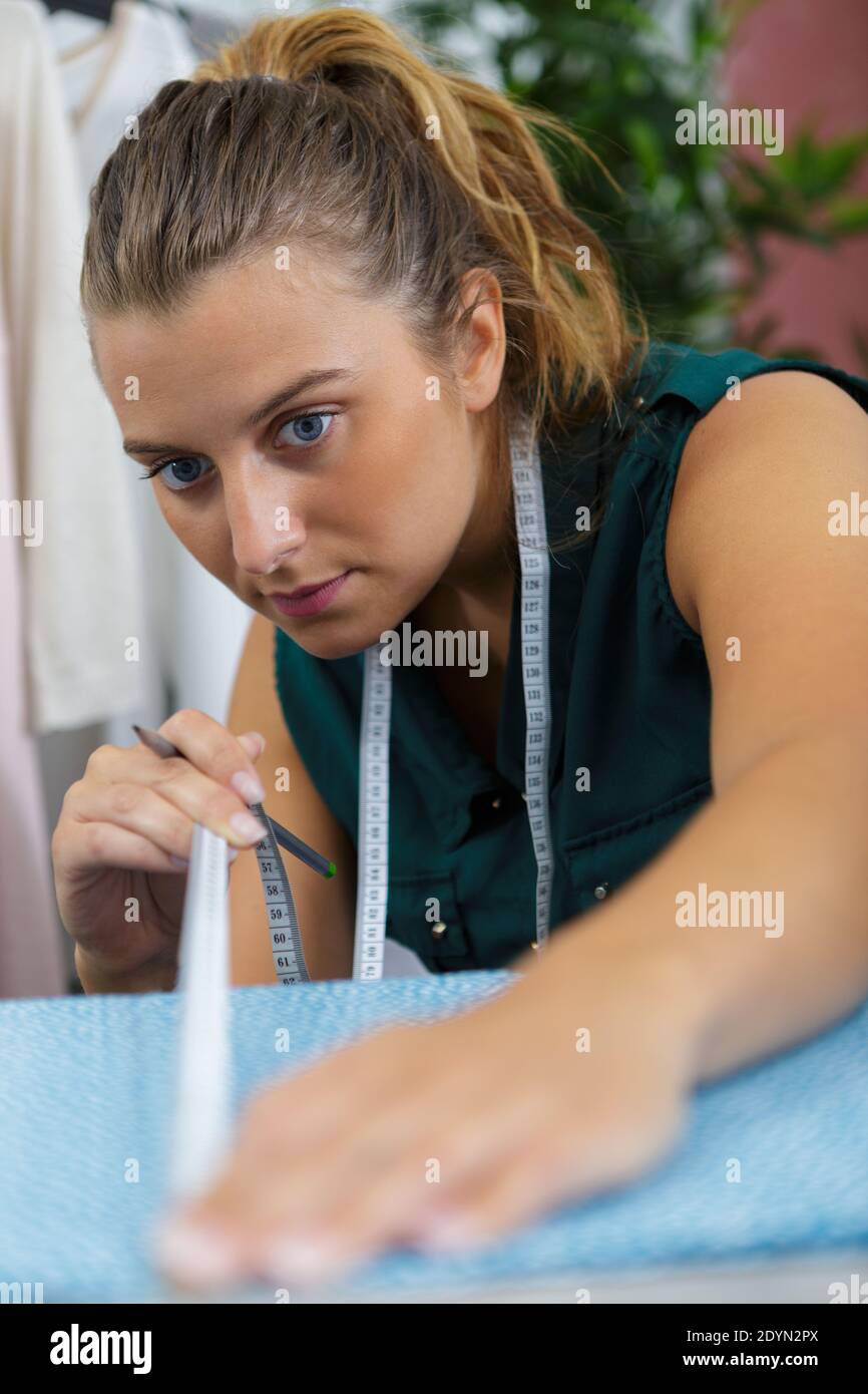 a serious seamstress measuring fabric Stock Photo - Alamy