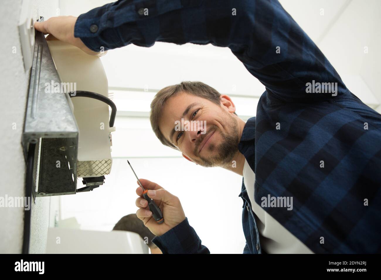 closeup photo of male technician installing air conditioning unit Stock ...