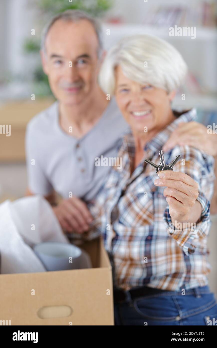 senior couple showing house keys light effect Stock Photo - Alamy