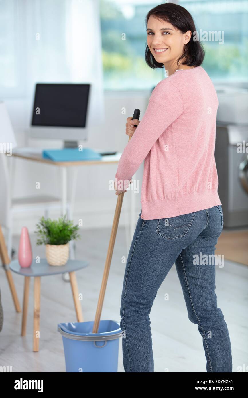 beautiful young woman cleaning floor at home using a mop Stock Photo - Alamy