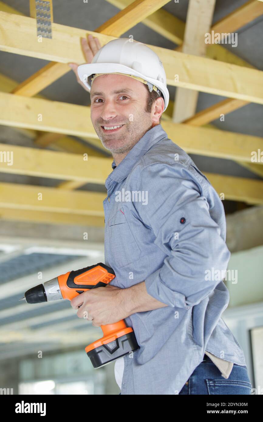 workman fixing roof beam with cordless drill Stock Photo - Alamy