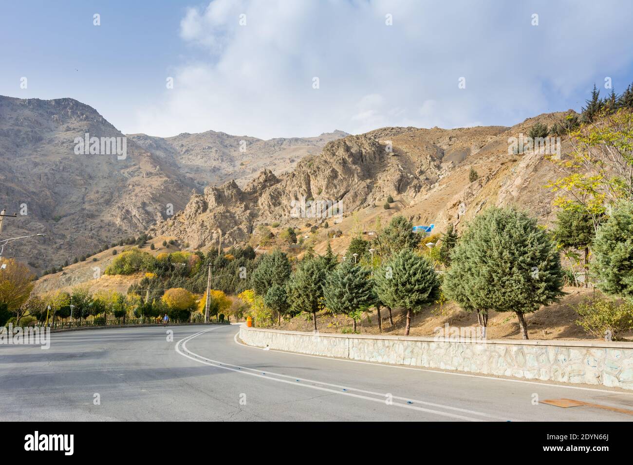 Tochal mountain ridge with rocks and trees in autumn against blue sky ...