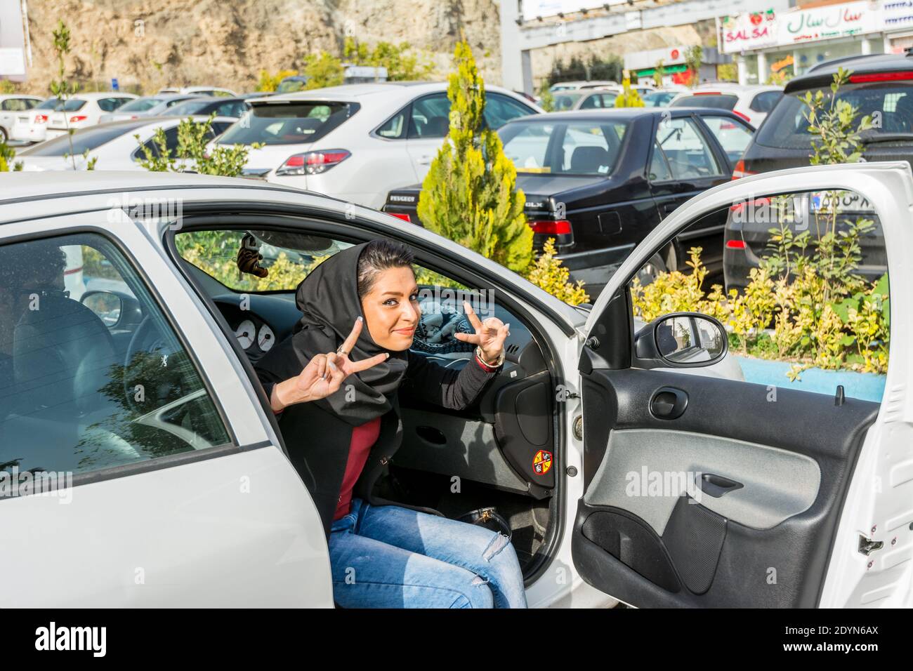 A female visitor sitting a car at the Tochal parking lot of the Tochal ...