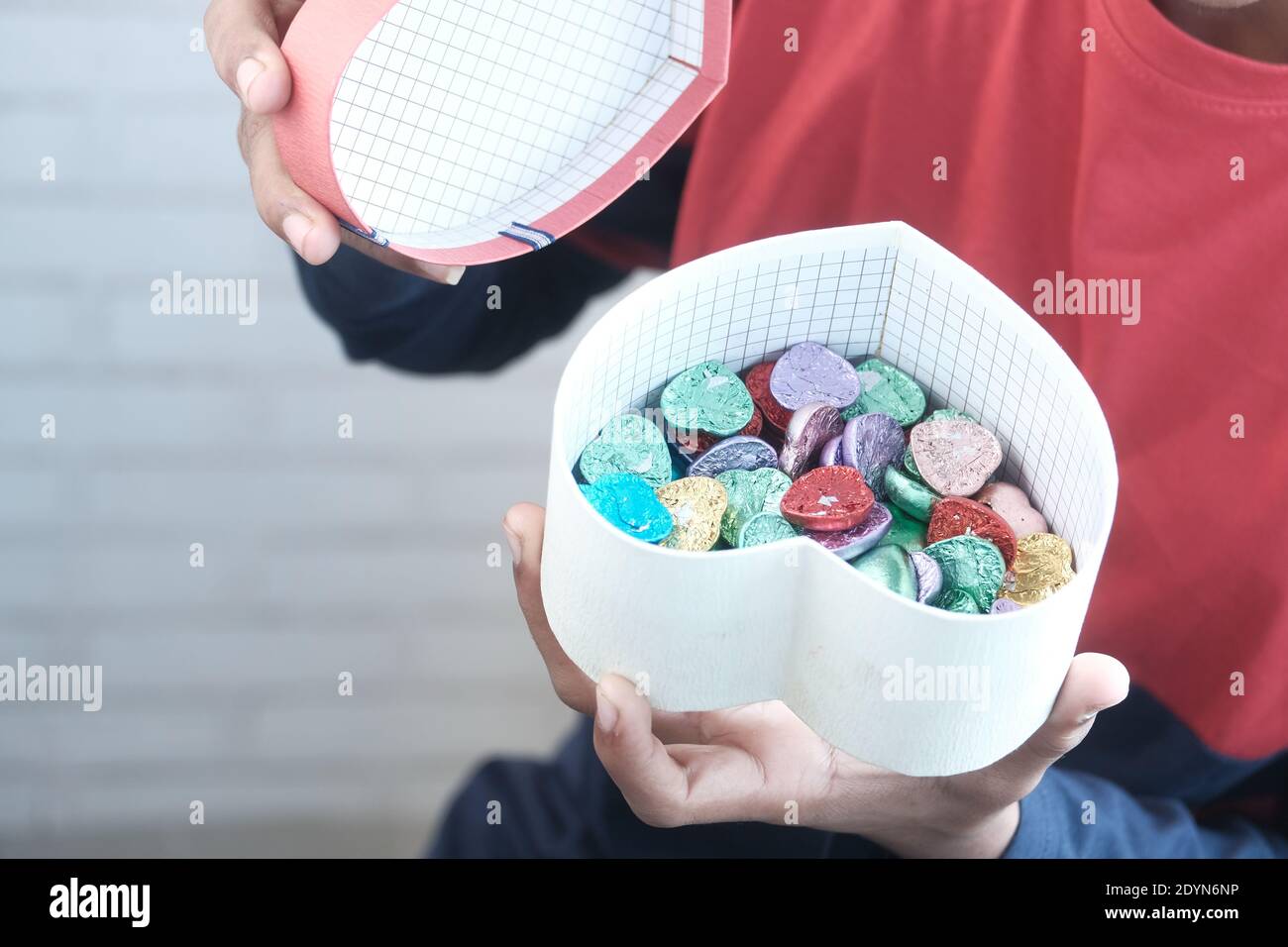 man's hand holding a gift box with full of candy Stock Photo - Alamy