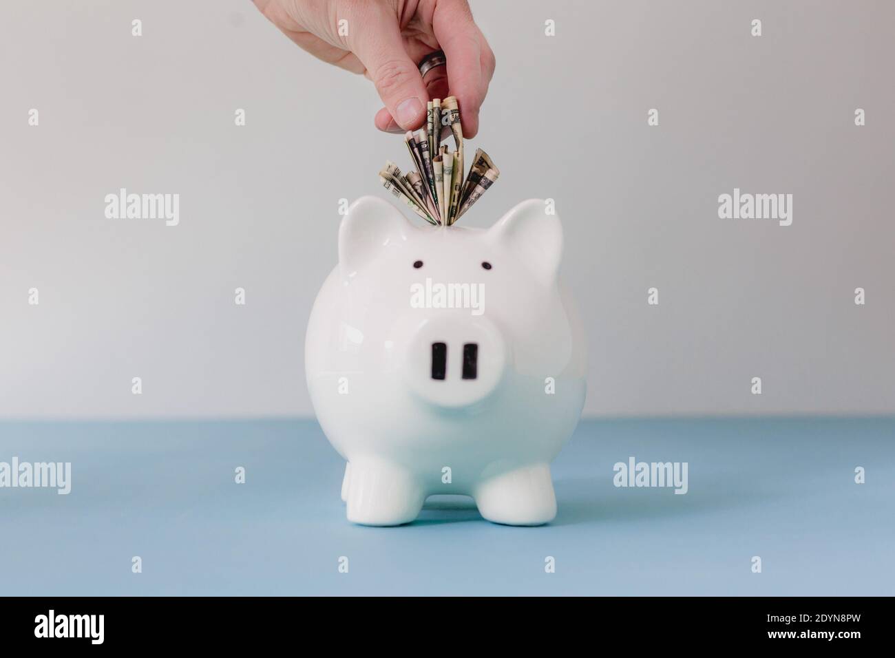 hand putting money in bank Stock Photo - Alamy
