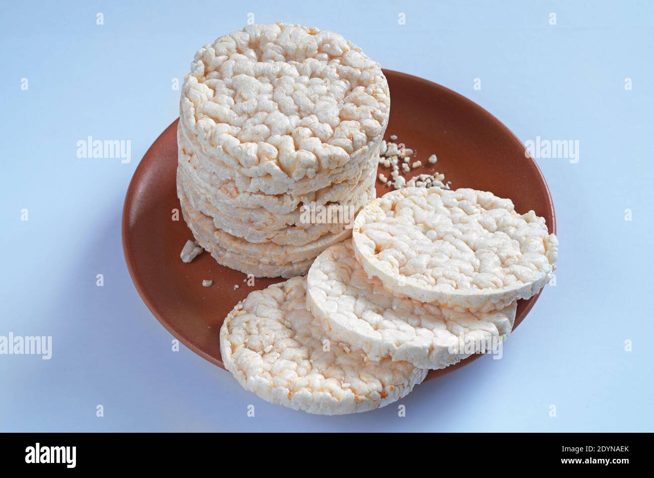 Rice crackers in brown plate on blue background Stock Photo - Alamy