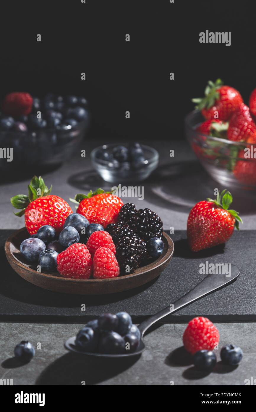 Mixed berries on dark background. Vertical format Stock Photo - Alamy