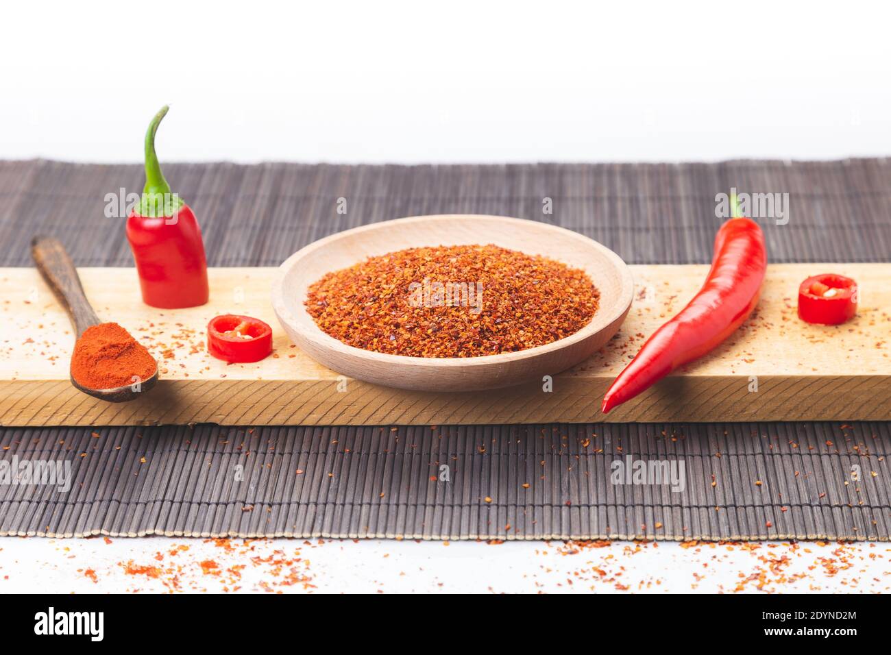 Red chili pepper sliced and Chilli powder scattered on wooden base on ...