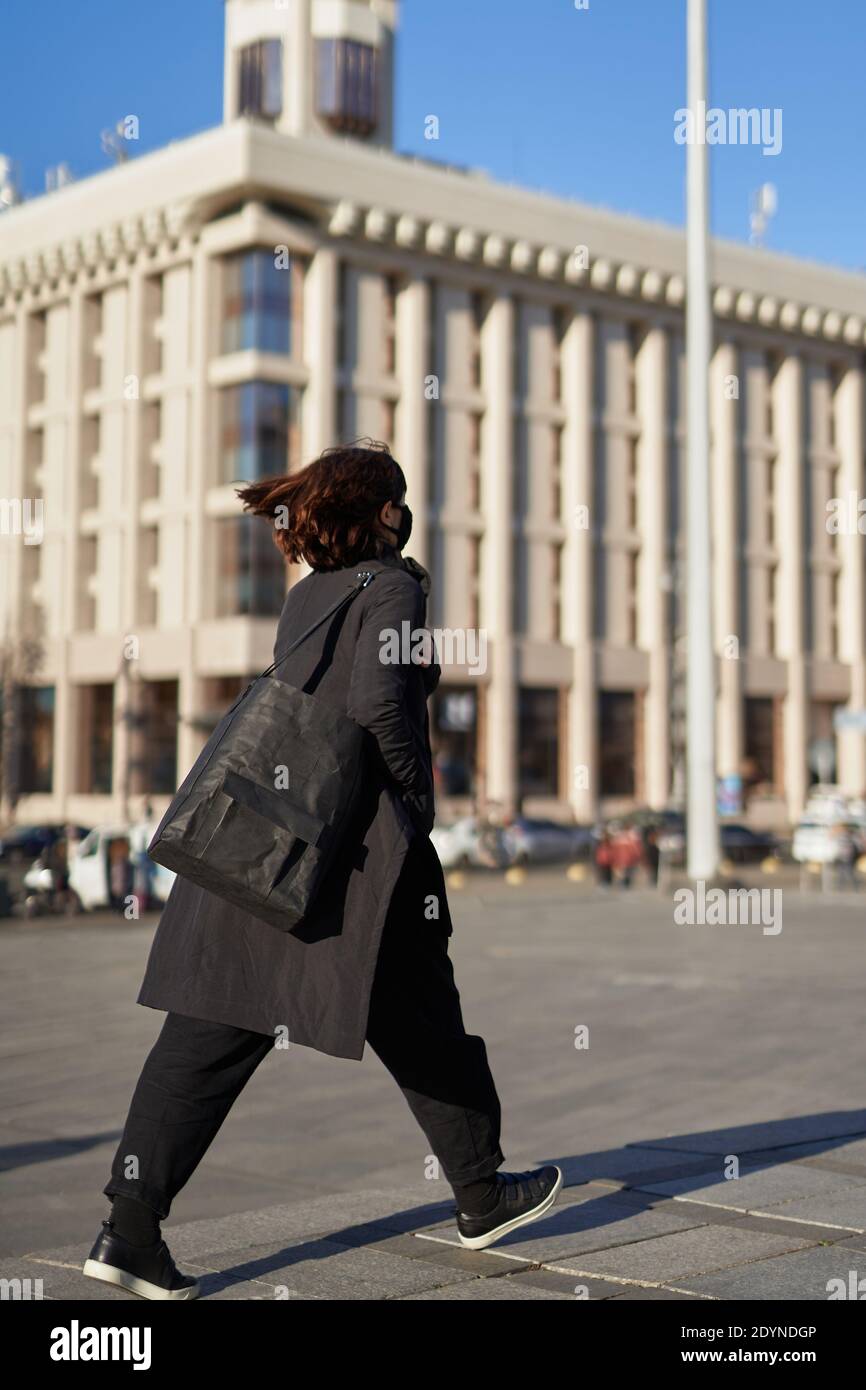 Young woman walking in a hurry and wearing black clothes on the ...