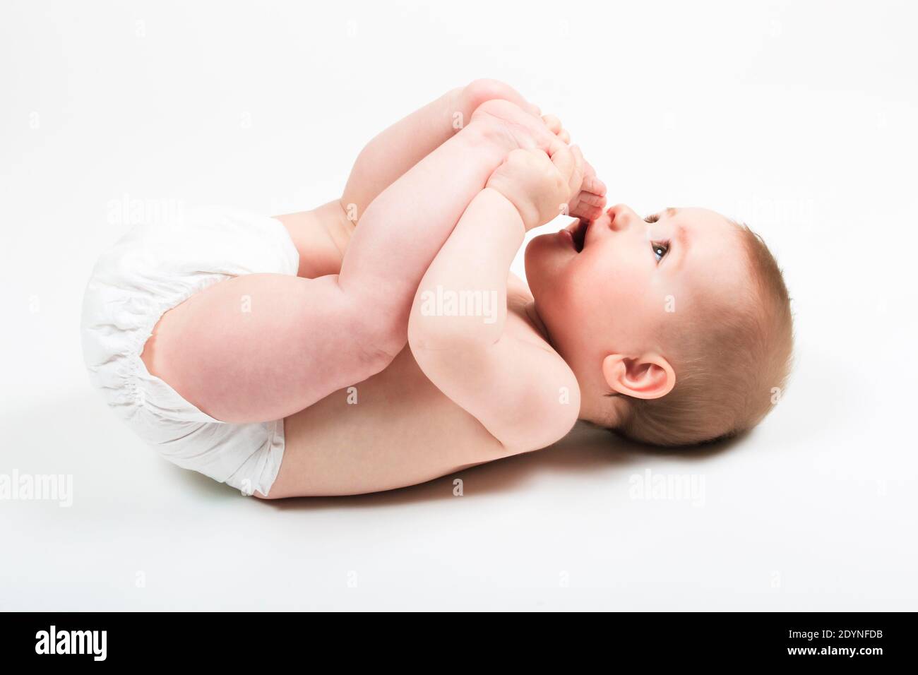 Baby lies on back and plays with his feet Stock Photo - Alamy