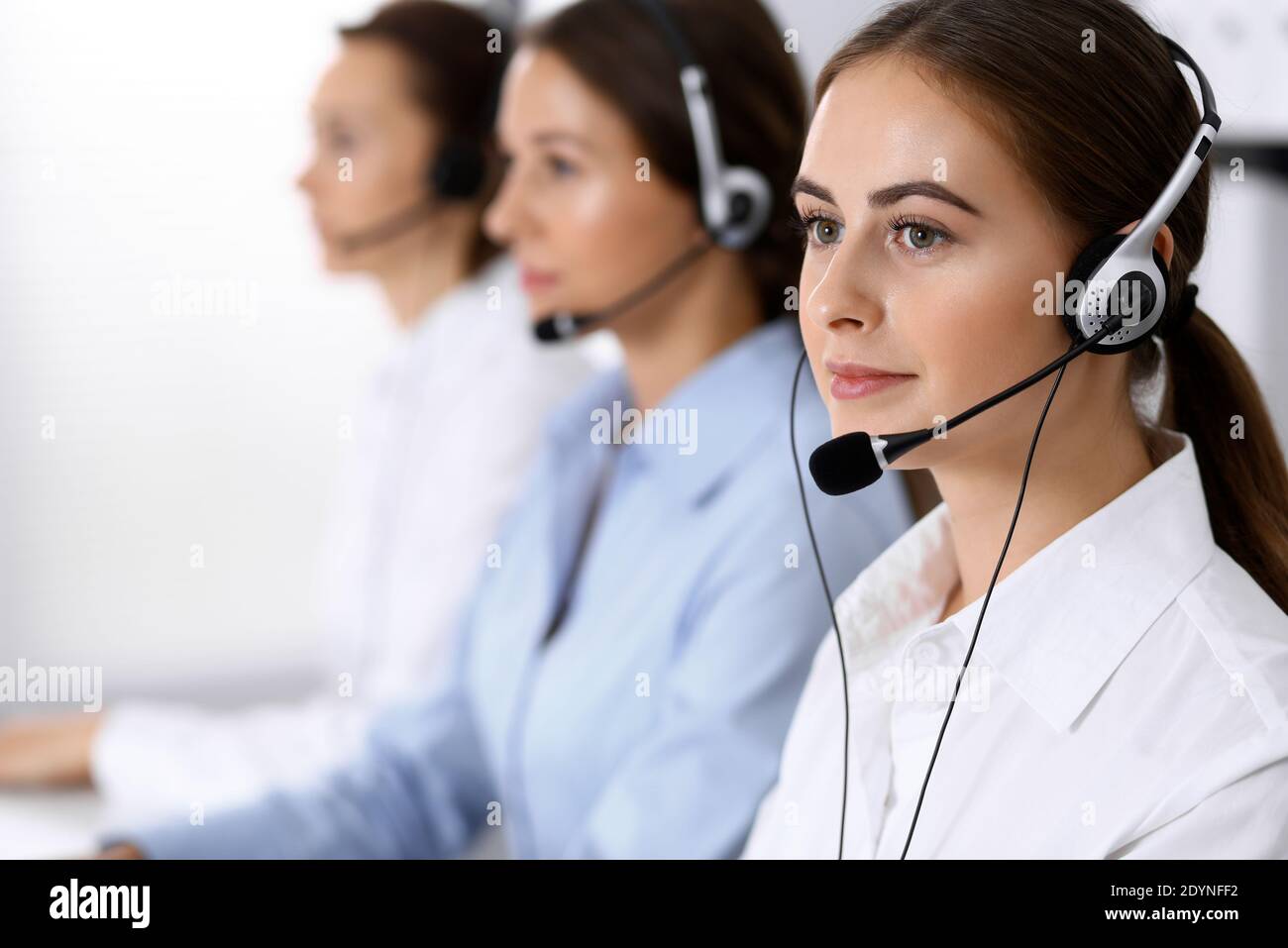 Call center. Group of operators at work. Fo us on beautiful business woman in headset Stock ...