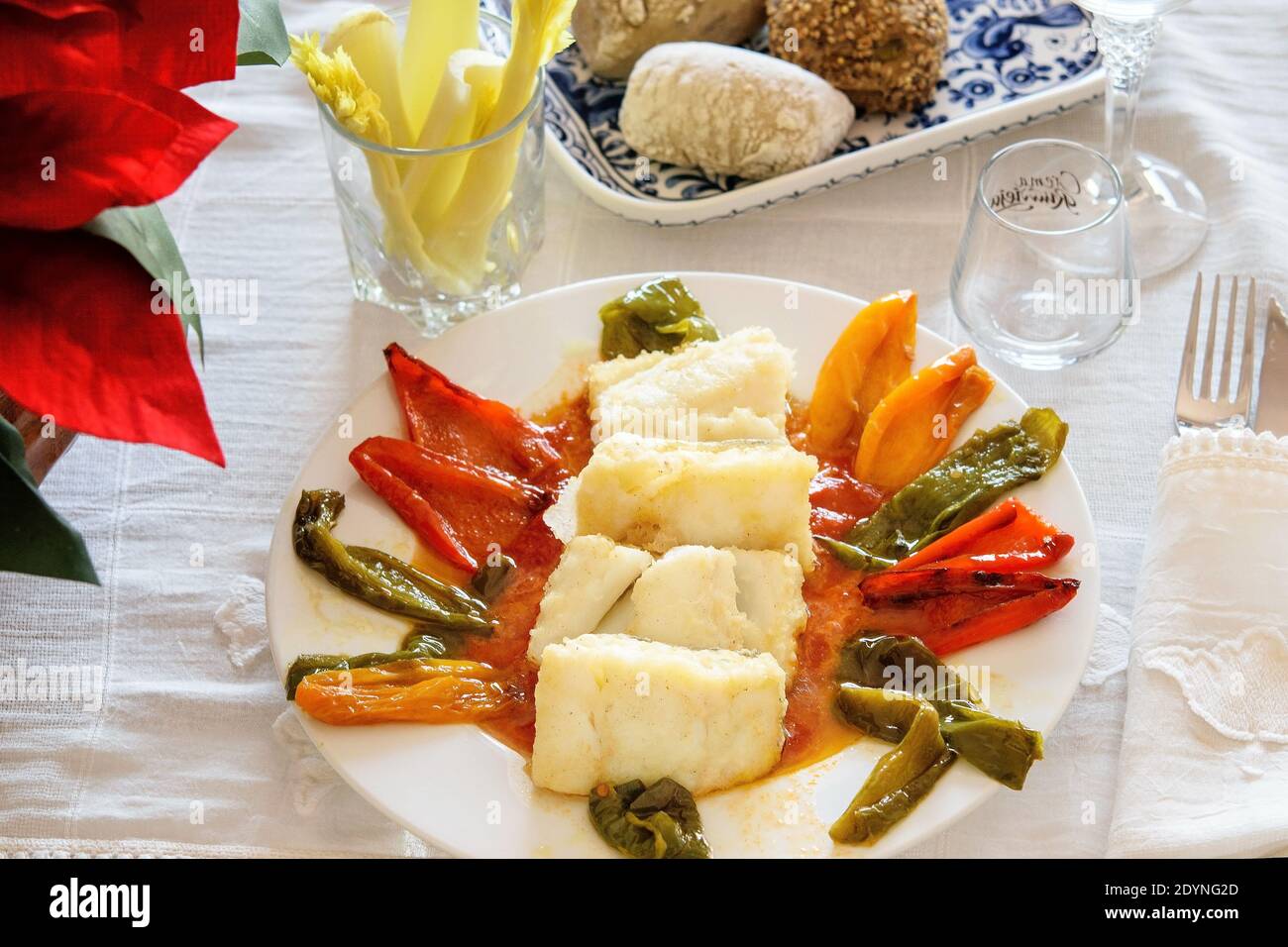 Slices of fried cod fish with slices of sweet bell peppers on the white ...