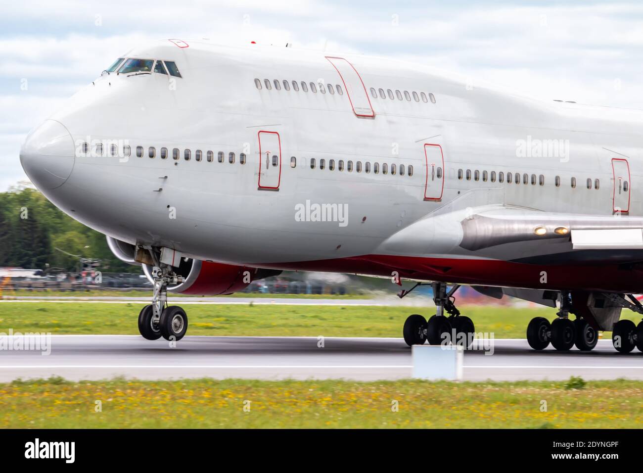 A large white wide-body passenger aircraft takes off from the airport ...