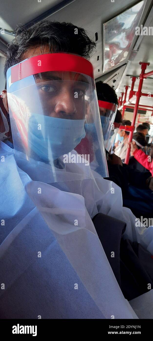 An Indian flight passenger sitting inside an aircraft bus while wearing ...