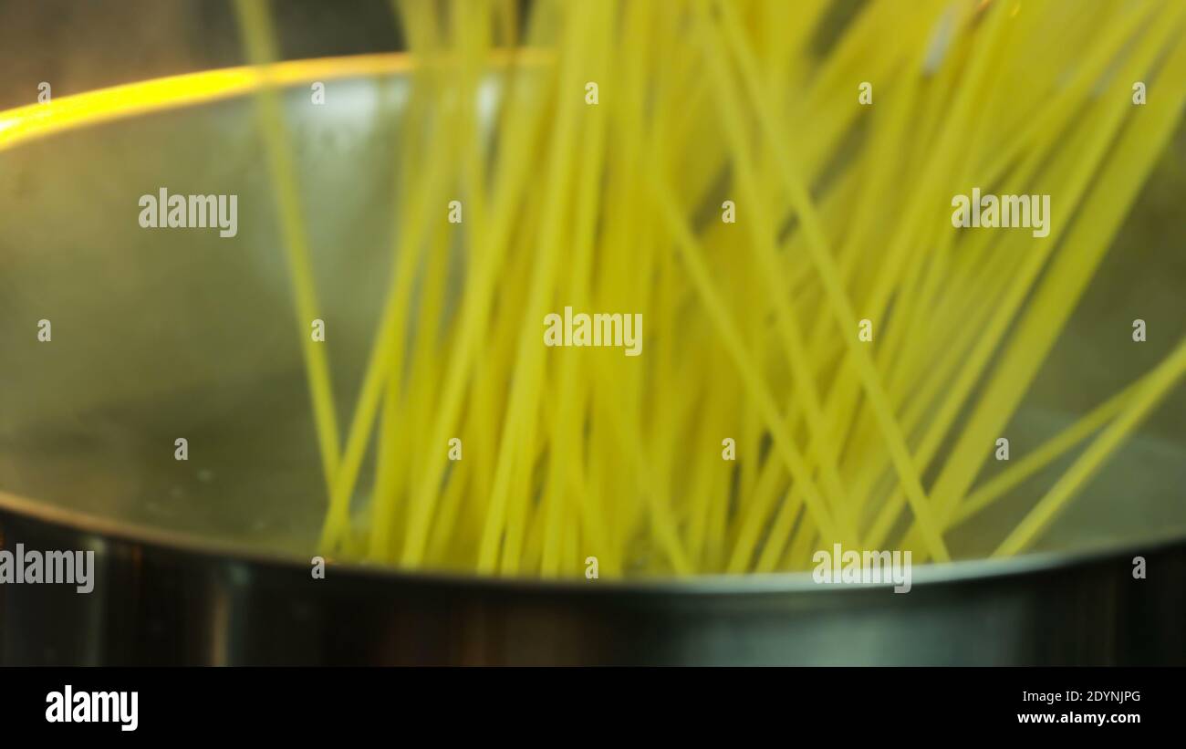 Adding Spaghetti to Pan Stock Photo - Alamy