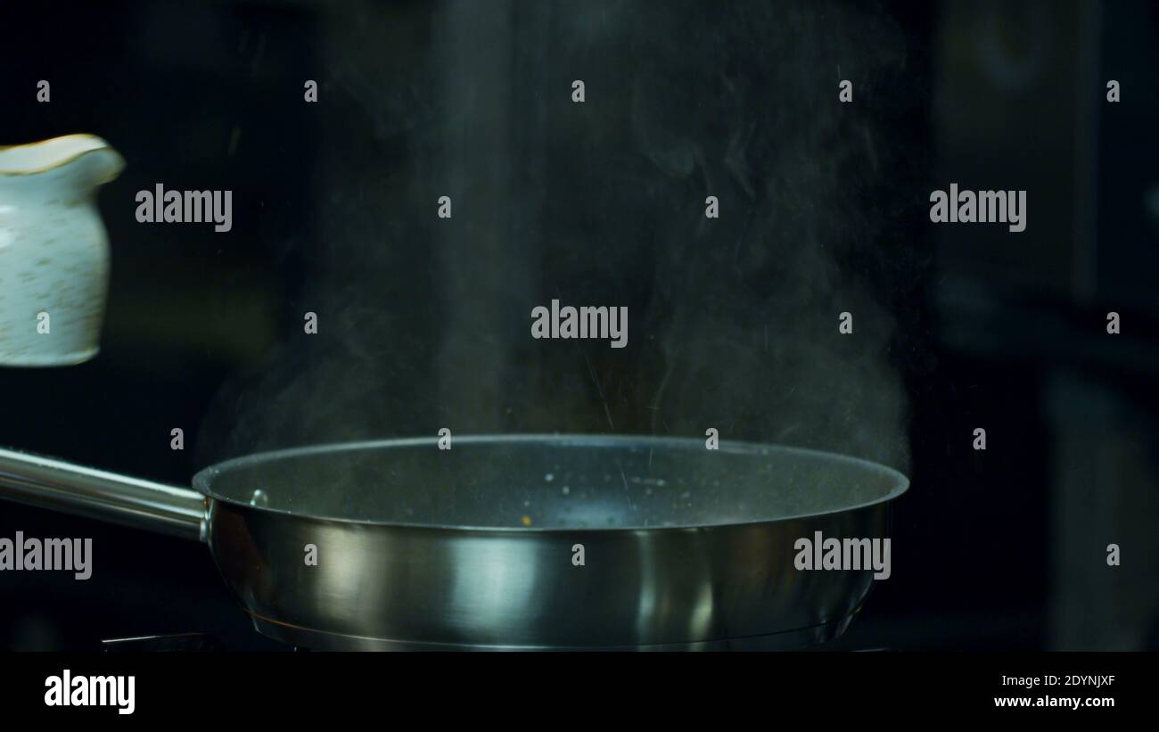 Chef adding oil pan slow hi-res stock photography and images - Alamy