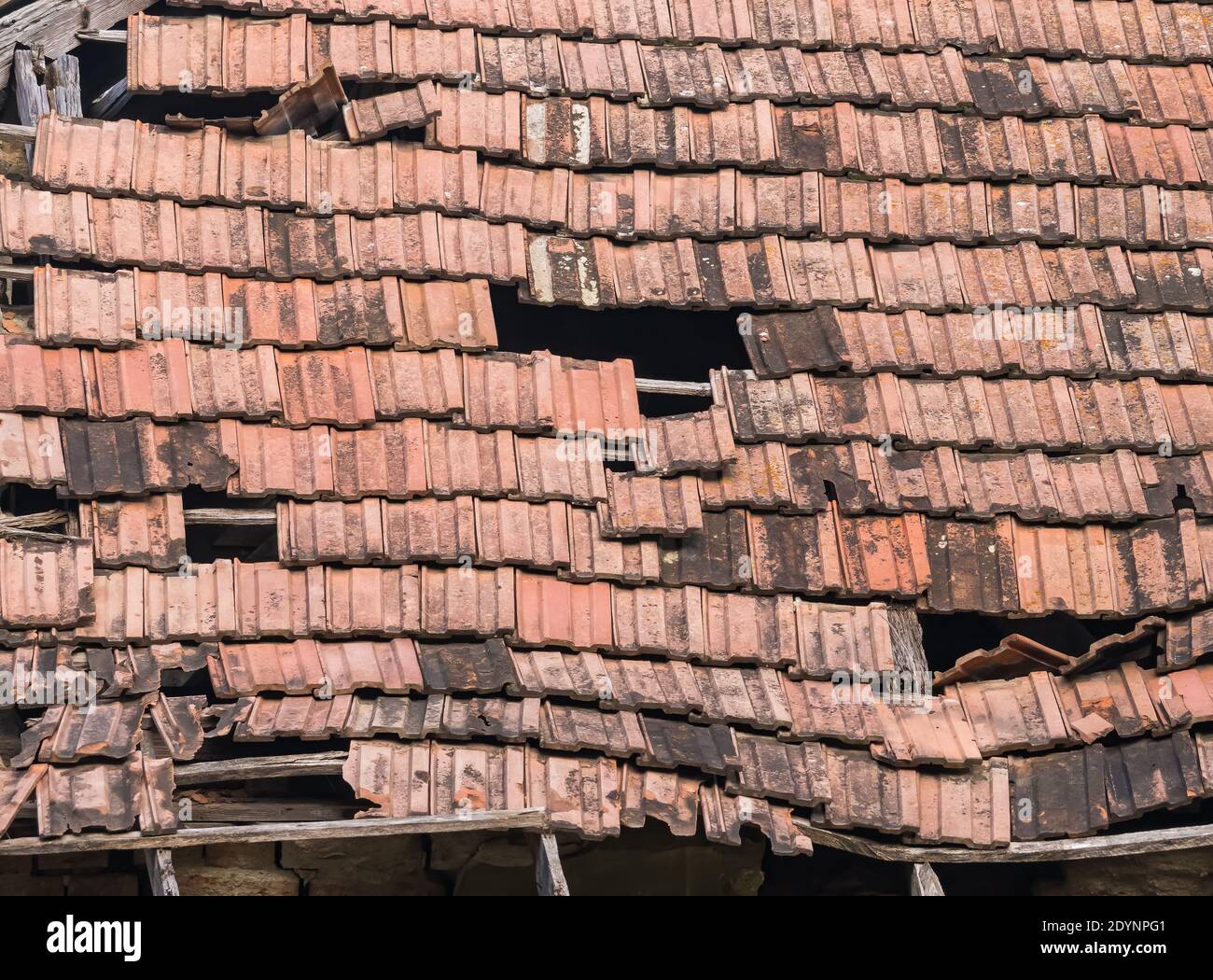 Old worn out red brick roof with missing tiles Stock Photo - Alamy