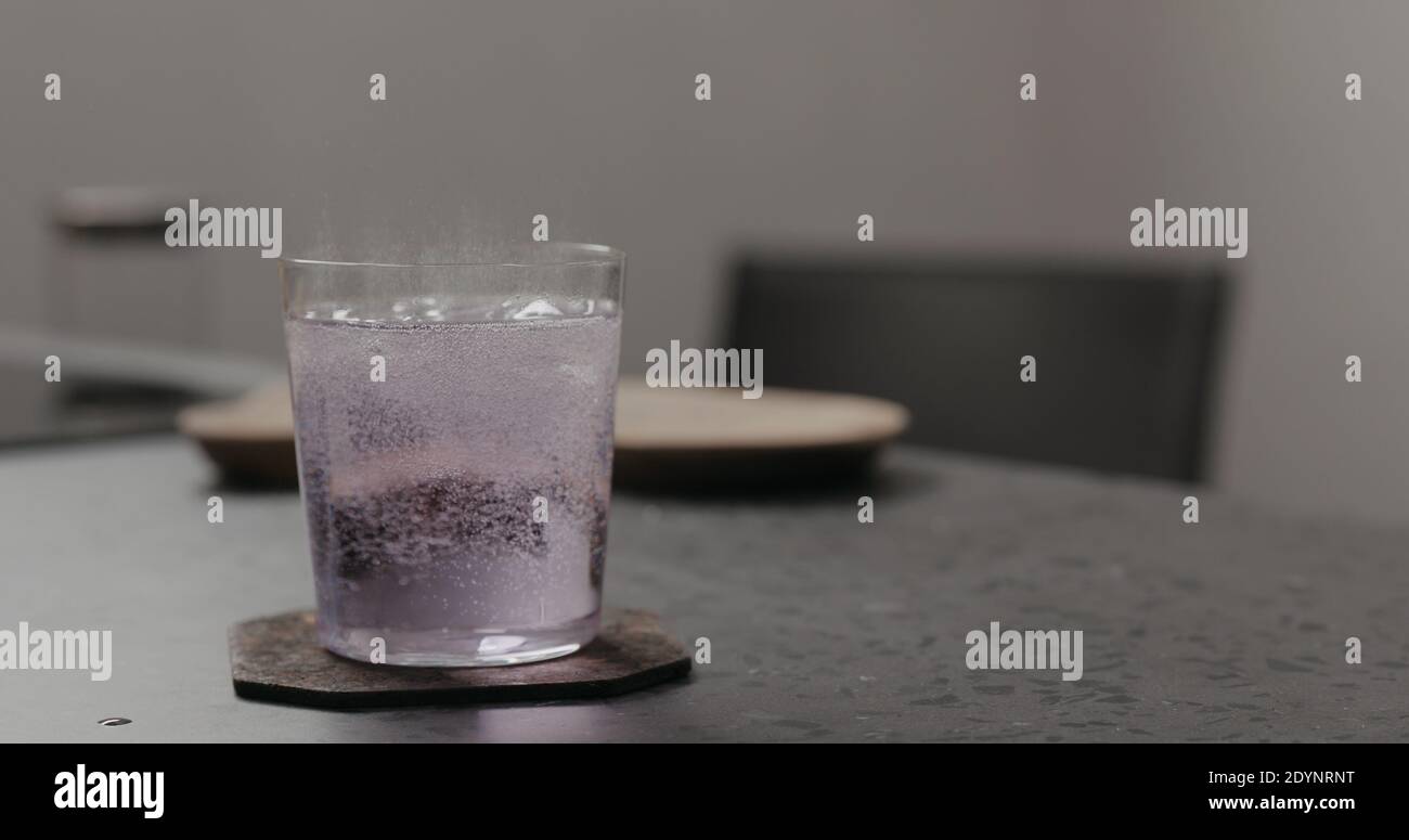purple fizzy drink in a tumbler glass from concrete countertop ...