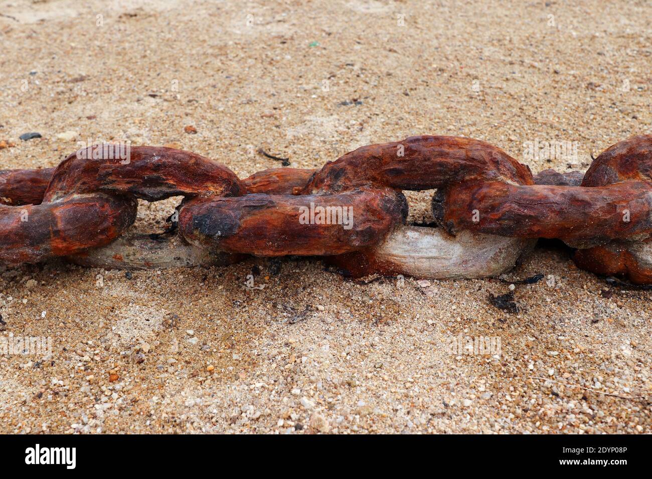 Old rusty chain on the beach sand Stock Photo - Alamy