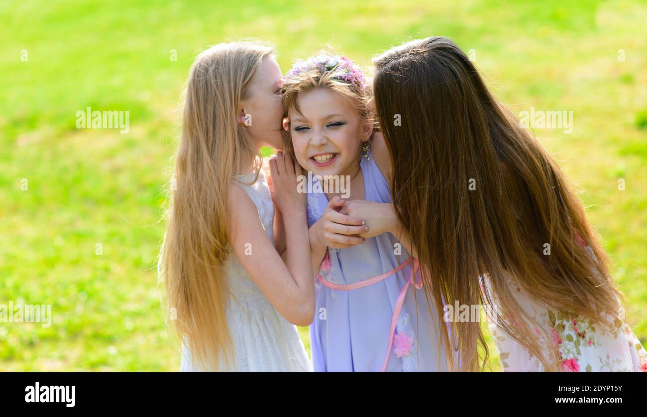Three adorable girls in dresses hold hands in a circle holding hands ...