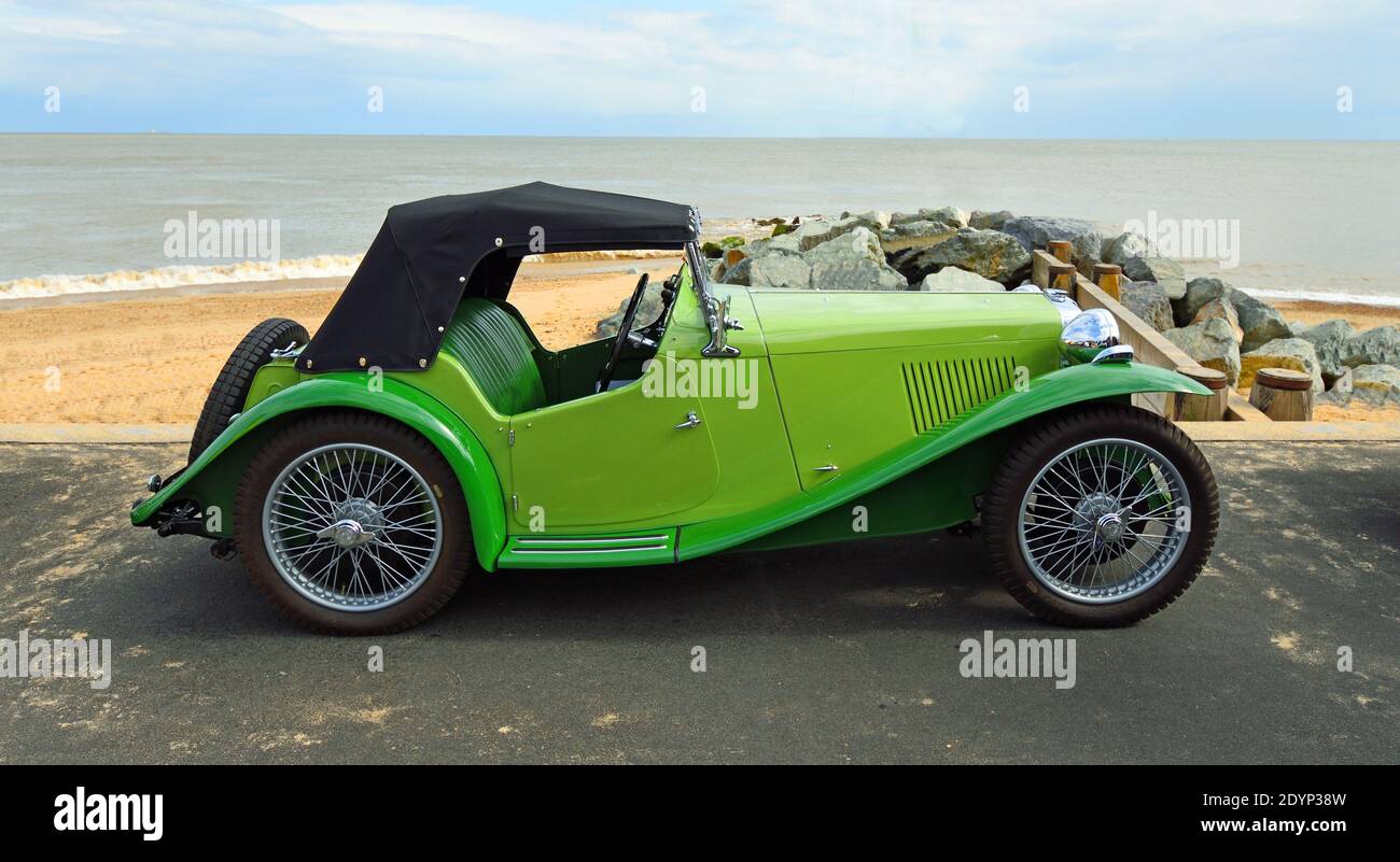 Classic Green MG Sports Car parked on seafront promenade with beach and ...