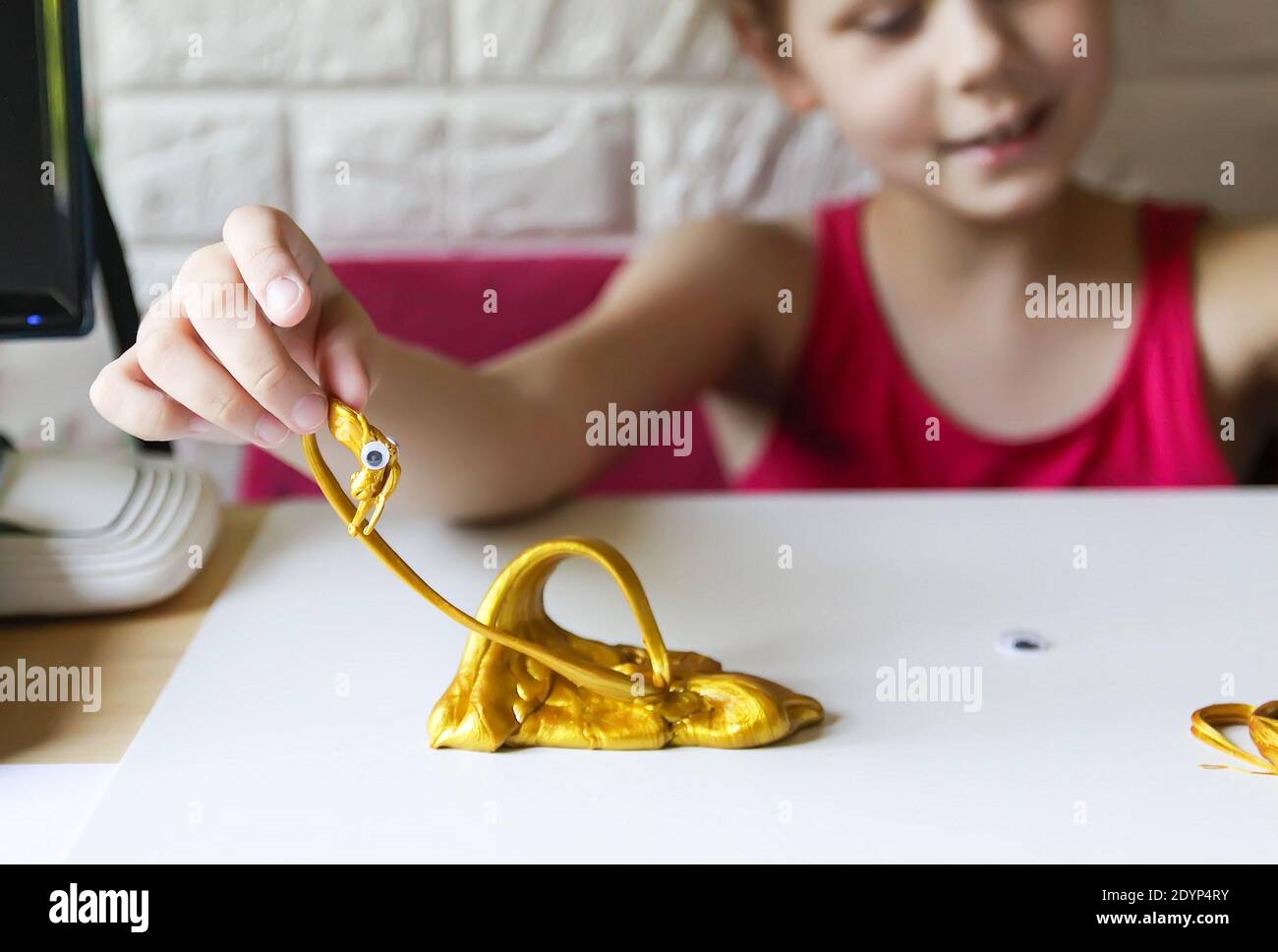 Little girl playing with the gold slime. Sensory activity for child ...