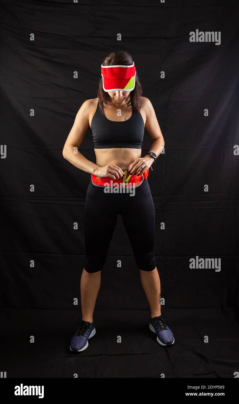 Beautiful redhead girl in jogging uniform posing in studio on black ...