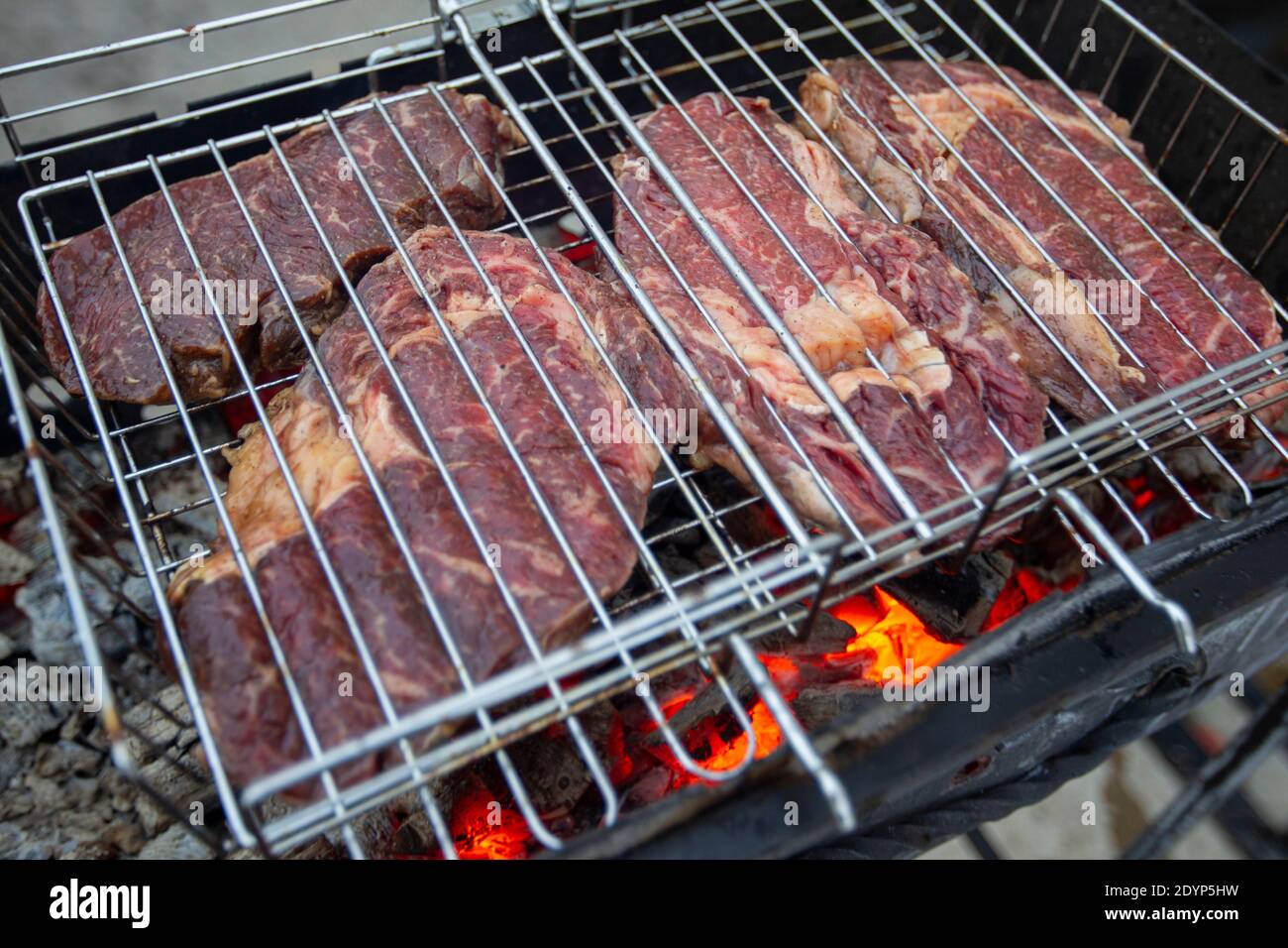 Large cuts of beef meat on the grill rack. Grilled barbecue meat Stock ...