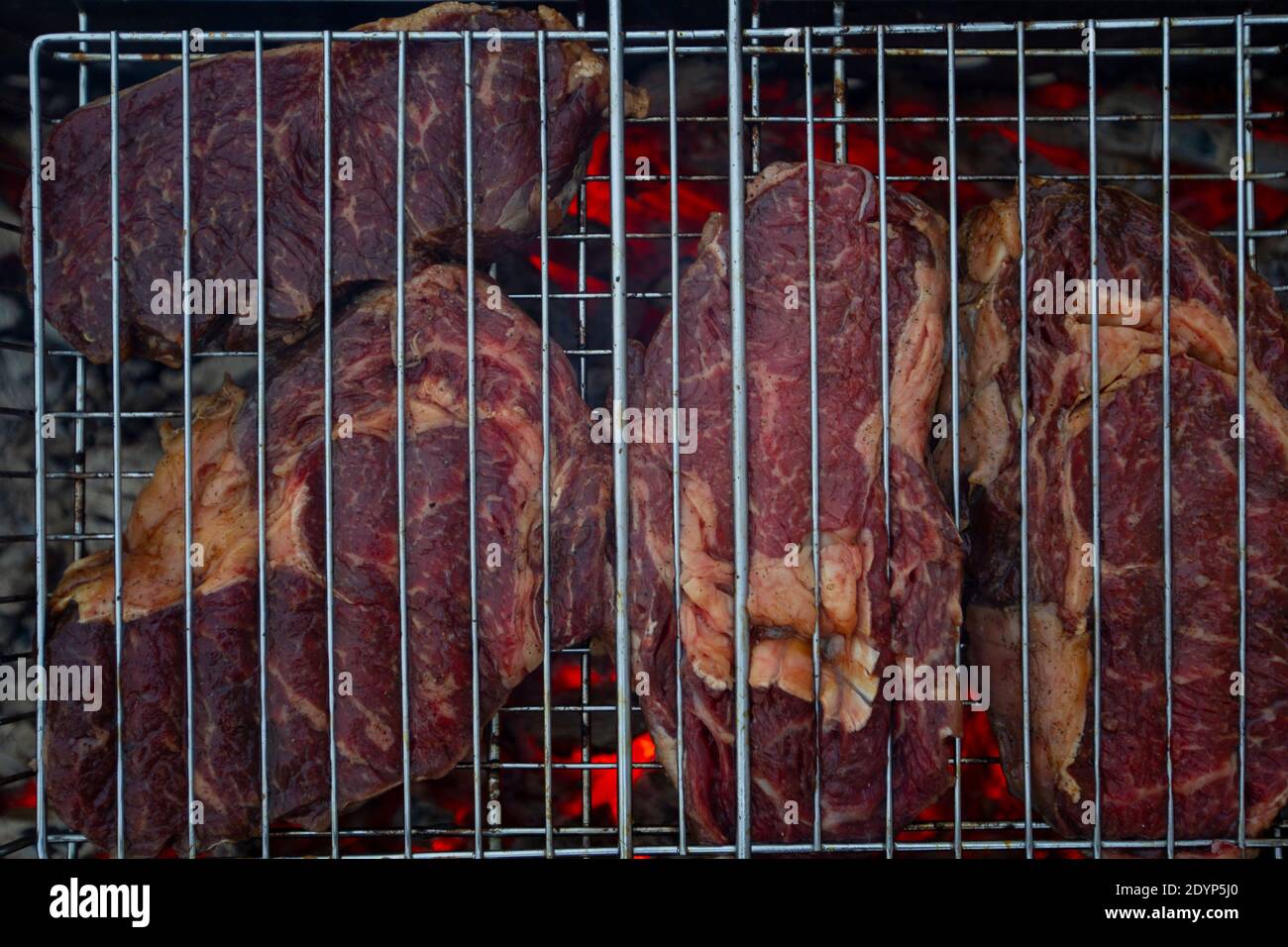 Large cuts of beef meat on the grill rack. Grilled barbecue meat Stock ...