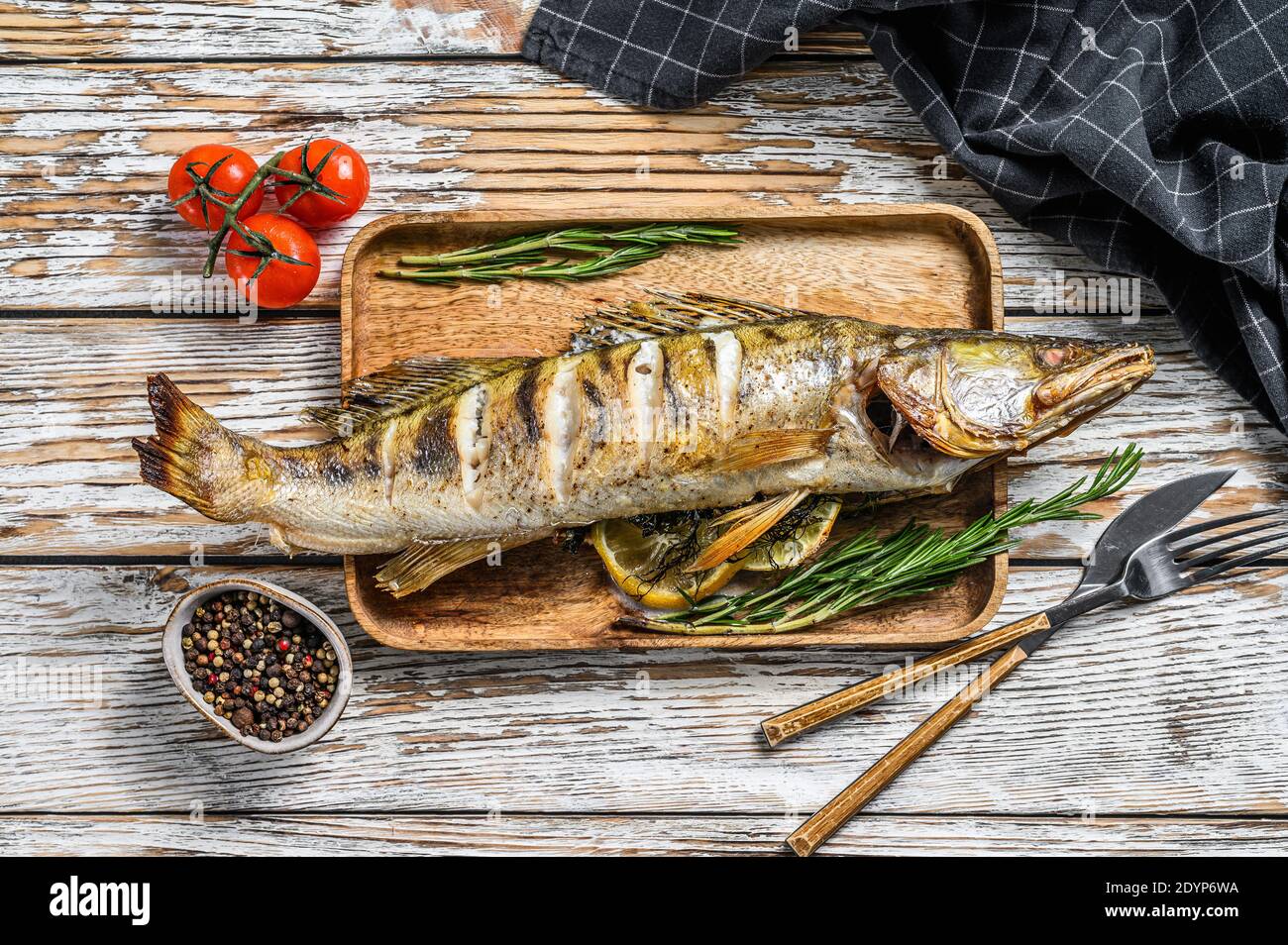 Baked Zander, walleye fish with herbs and lemon. White wooden ...