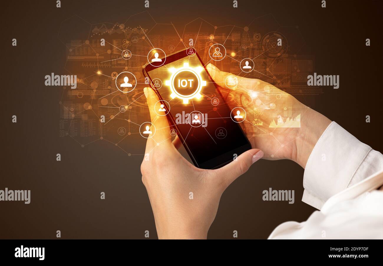 Female hand holding smartphone with IOT abbreviation, modern technology ...