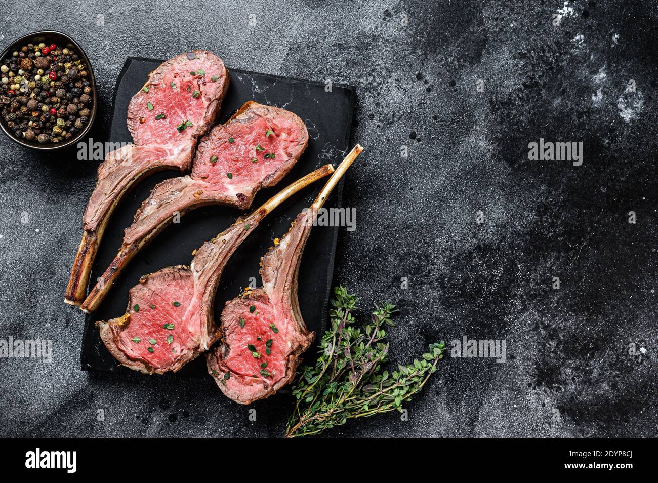 Roast lamb rib chop meat steaks on a marble board. Black background ...