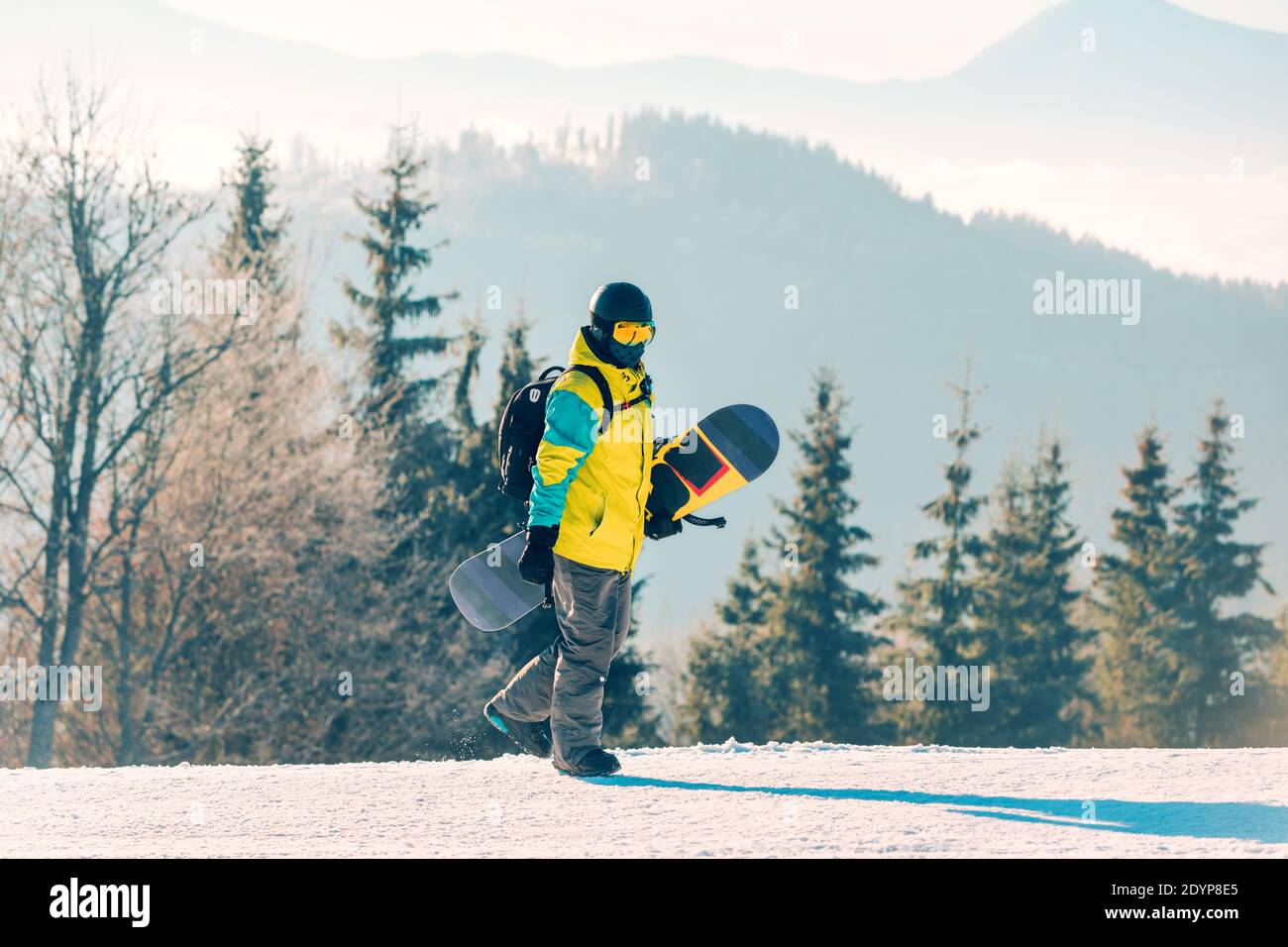 man walking by hill with snowboard Stock Photo - Alamy