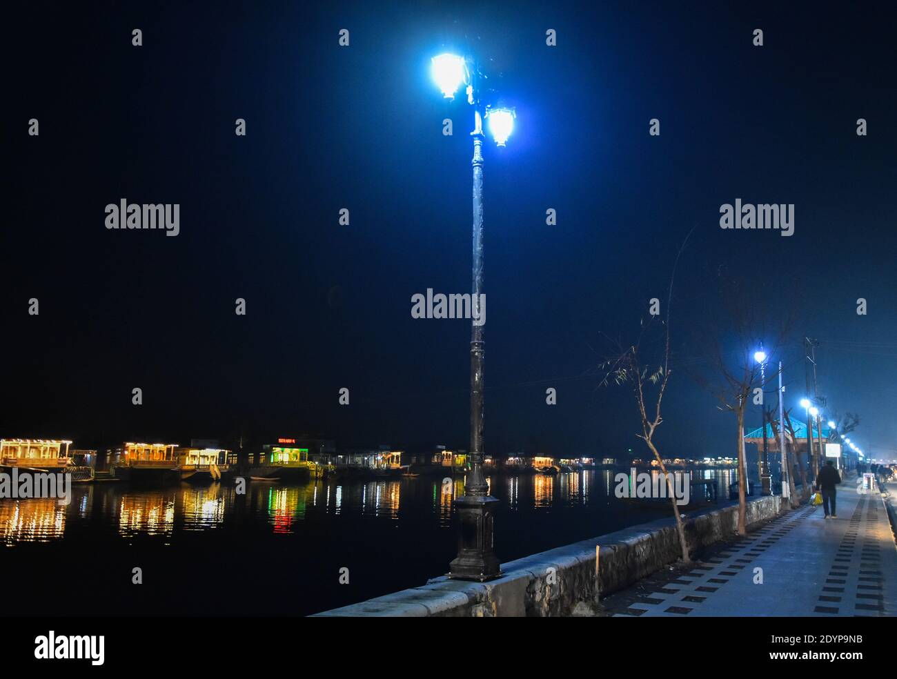 A man walks along the banks of Dal lake during a cold evening in ...