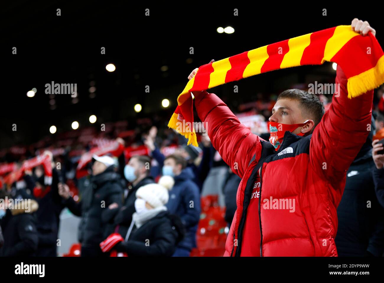 A Liverpool fan in the stands holds up a scarf prior to the beginning ...