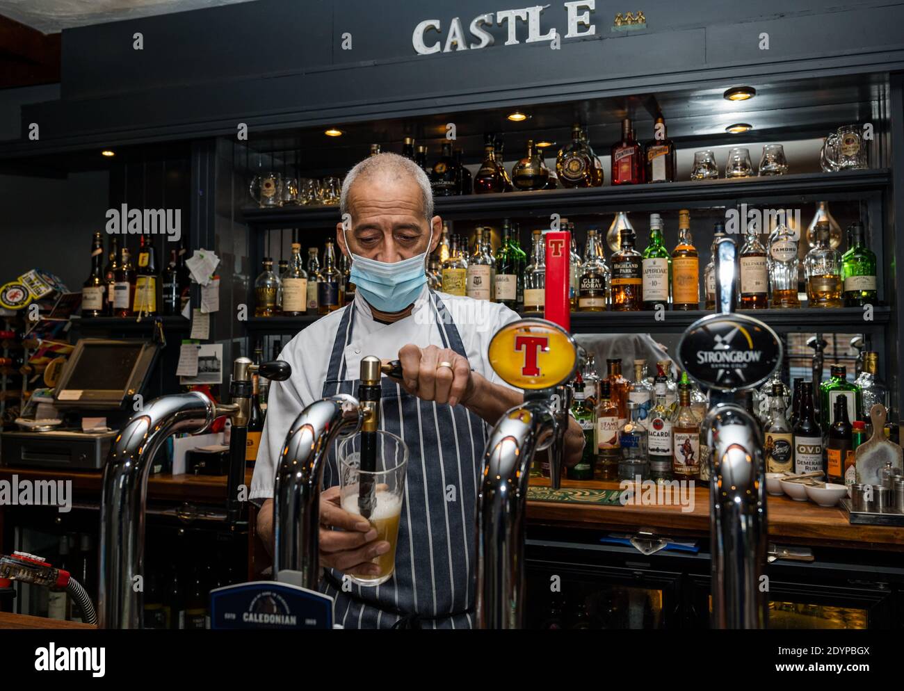 Bartender wearing apron & face mask during the Covid-19 pandemic ...