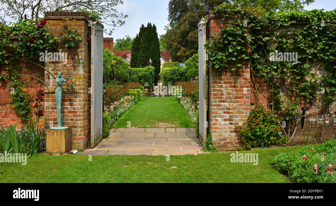Garden Gate with Plants and Statue Stock Photo - Alamy